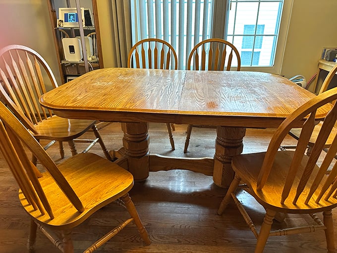 Solid oak dining set with Windsor chairs—the kind of craftsmanship that's outlasted three presidential administrations and countless family dinners.