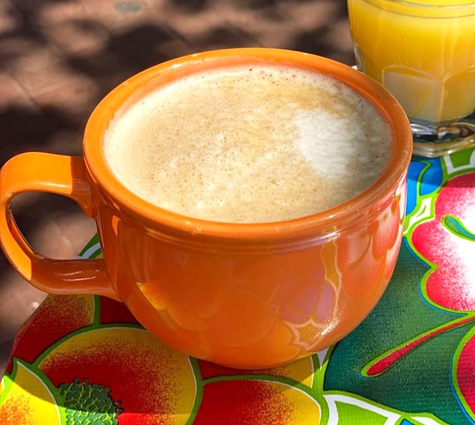 That orange mug isn't just holding coffee—it's cradling liquid motivation, the unsung hero of productive mornings everywhere.