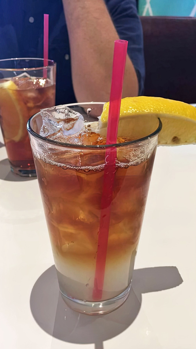 Iced tea with a pink straw and lemon wedge—because sometimes the simplest pleasures are the ones that keep you coming back for refills.