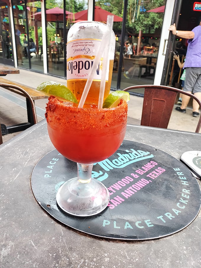 A proper Texas-sized Michelada with a chili-salt rim. The beer bottle turned upside down isn't giving up—it's contributing to the cause.