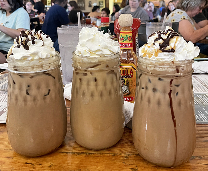 Mason jar frappes topped with whipped cream mountains—dessert masquerading as coffee, and nobody's complaining about the disguise.