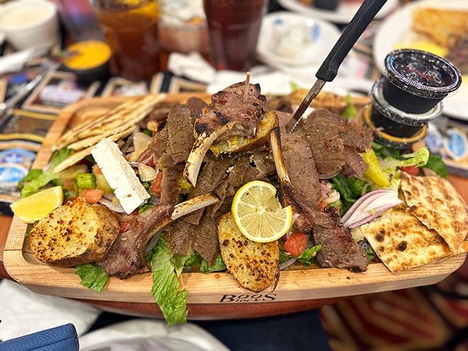The Greek gyro platter arrives like an edible postcard from the Mediterranean—a wooden board laden with seasoned meat, fresh vegetables, and warm pita.