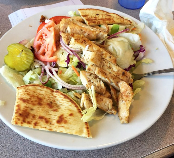 A salad that doesn't feel like punishment – grilled chicken, fresh veggies, and pita bread that makes healthy eating feel like cheating.