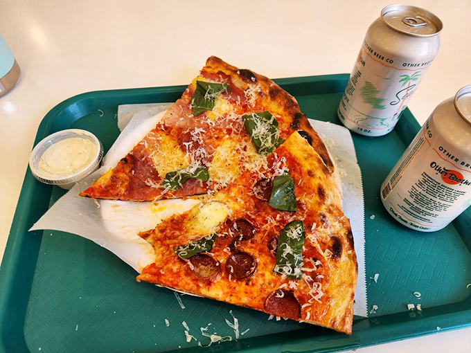 Pizza perfection served on a cafeteria tray with canned beverages—proof that greatness doesn't need fancy presentation. Just give me that slice and stand back.