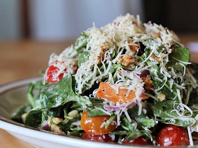 A salad that makes you forget you're being virtuous. Fresh greens, vibrant veggies, and a snowfall of cheese—health food never looked so tempting.