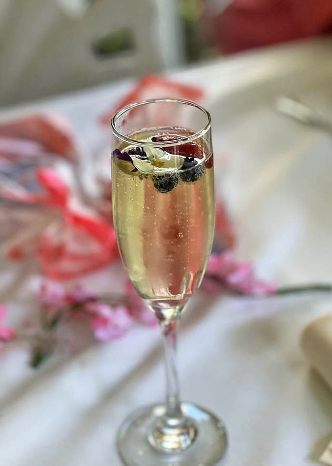 A champagne flute with berries floating like tiny jewels—because Tuesday afternoons sometimes need their own celebration.
