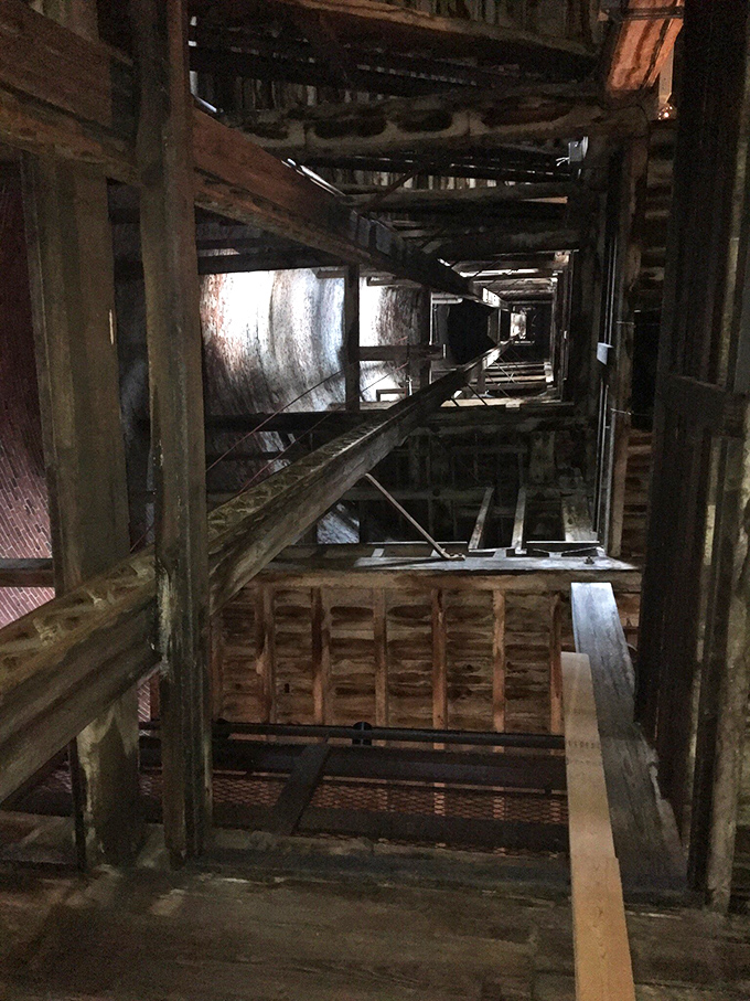 Looking up through the tower's wooden skeleton is like peering into industrial archaeology—where molten lead once fell, tourists now gaze in wonder.