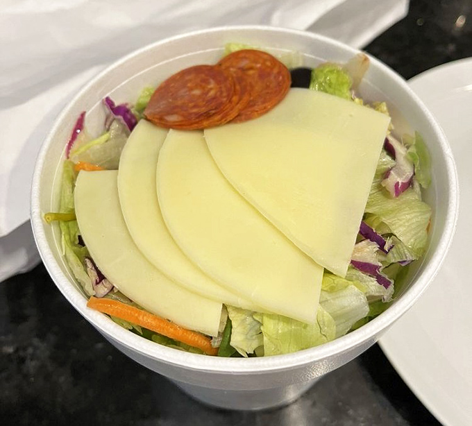 An Italian salad that doesn't apologize for its simplicity—crisp lettuce, generous cheese slices, and pepperoni that reminds you vegetables are just pizza topping delivery vehicles.