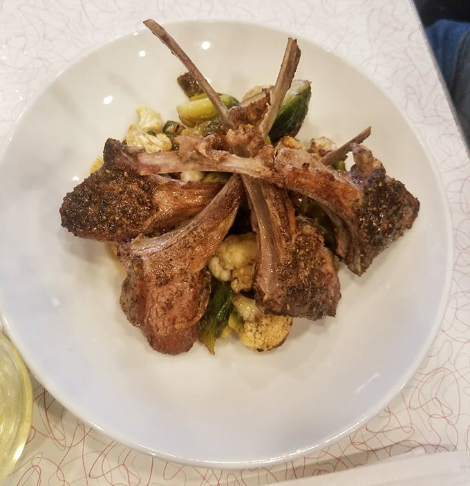Lamb chops standing at attention like delicious sentinels guarding the vegetables beneath—a dish worth crossing state lines for.