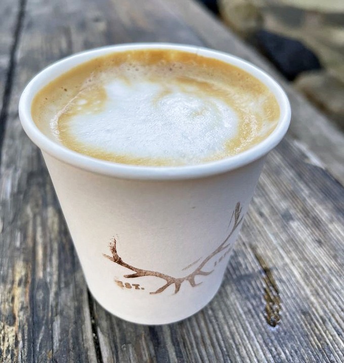 Coffee with a view – this isn't just caffeine, it's mountain-air therapy in a cup emblazoned with antlers, because of course it is.