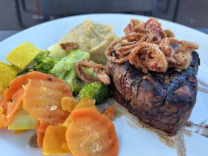 Steak that's dressed for success. This mignon wears its crispy onion crown with pride, surrounded by a colorful vegetable entourage.