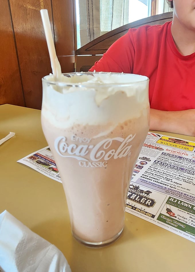 The milkshake arrives in its natural habitat – a classic Coca-Cola glass, thick enough to make your straw stand at attention.