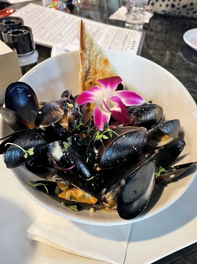 These mussels aren't just served, they're presented—a maritime treasure chest opened tableside with that grilled bread standing by for essential sauce-sopping duty.