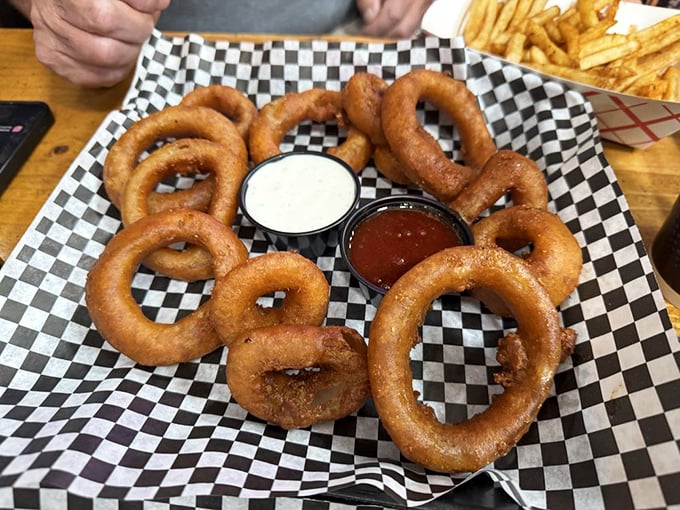 These onion rings aren't just side dishes—they're golden halos of crispy perfection that deserve their own moment of silent appreciation.
