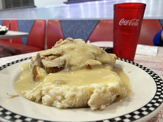 An open-faced turkey sandwich swimming in gravy—the kind of honest plate that makes you want to call your mother and thank her.
