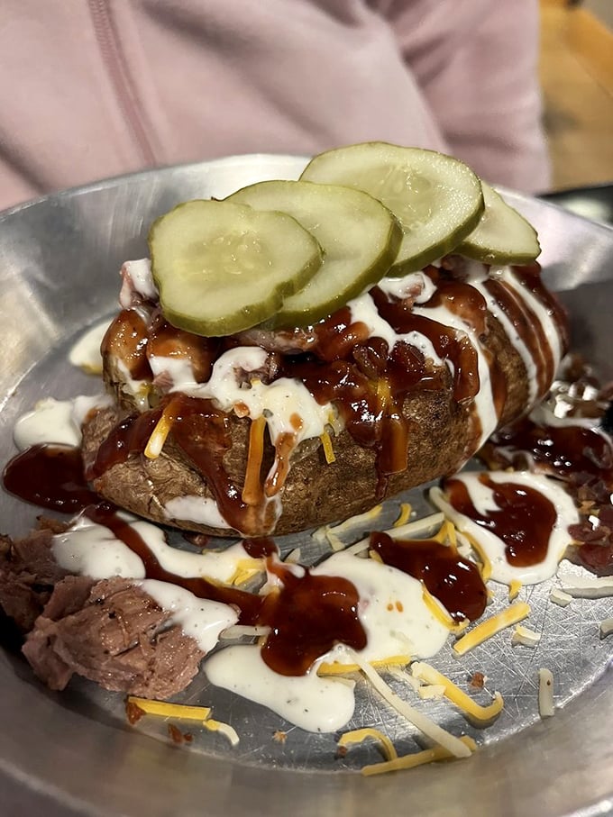 This isn't just a baked potato—it's a canvas for barbecue artistry, complete with all the fixings and pickle coins for good measure.