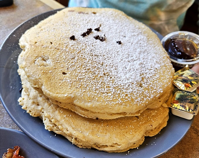 These pancakes aren't just big—they're "I'll-have-to-skip-lunch" big, dusted with powdered sugar like the first perfect snowfall of winter.