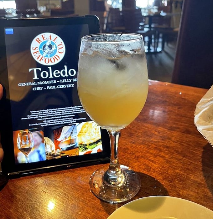 Golden peach sangria catching the light just right—proof that seafood isn't the only liquid treasure at this Toledo gem.