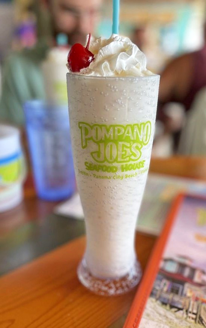 A piña colada tall enough to hide behind during awkward conversations, topped with whipped cream and a cherry that says "vacation starts now."