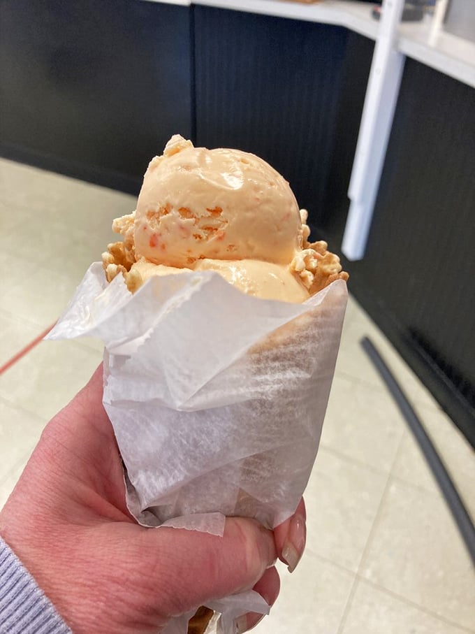 Ice cream with a view. The red barn backdrop confirms you're not hallucinating this creamy masterpiece – though you might dream about it later.