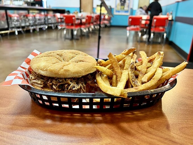 This pulled pork sandwich doesn't just fall apart—it surrenders completely to your appetite, with fries standing by as willing accomplices.