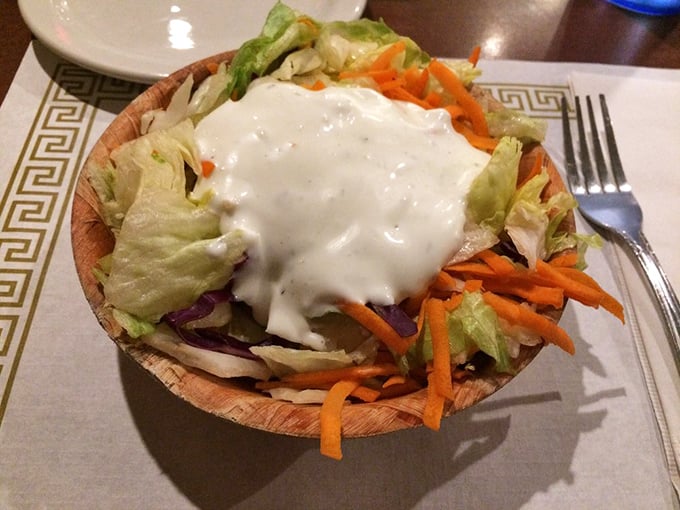 A salad served in a wooden bowl that somehow makes vegetables more appealing. It's not avoiding barbecue—it's supporting the main event.