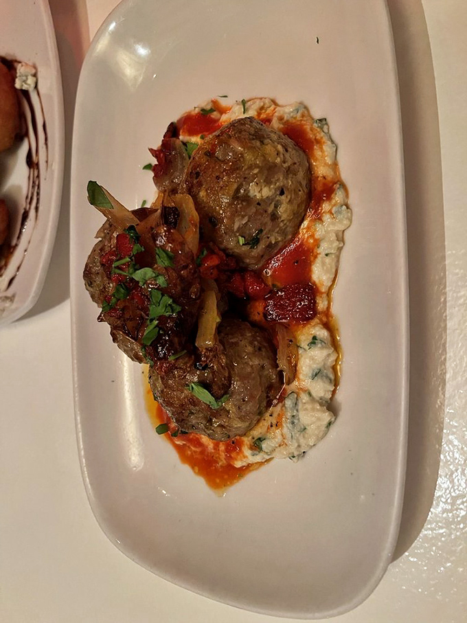 These aren't just meatballs—they're meaty islands in a sea of savory sauce, resting on clouds of creamy goodness that demand to be savored slowly.
