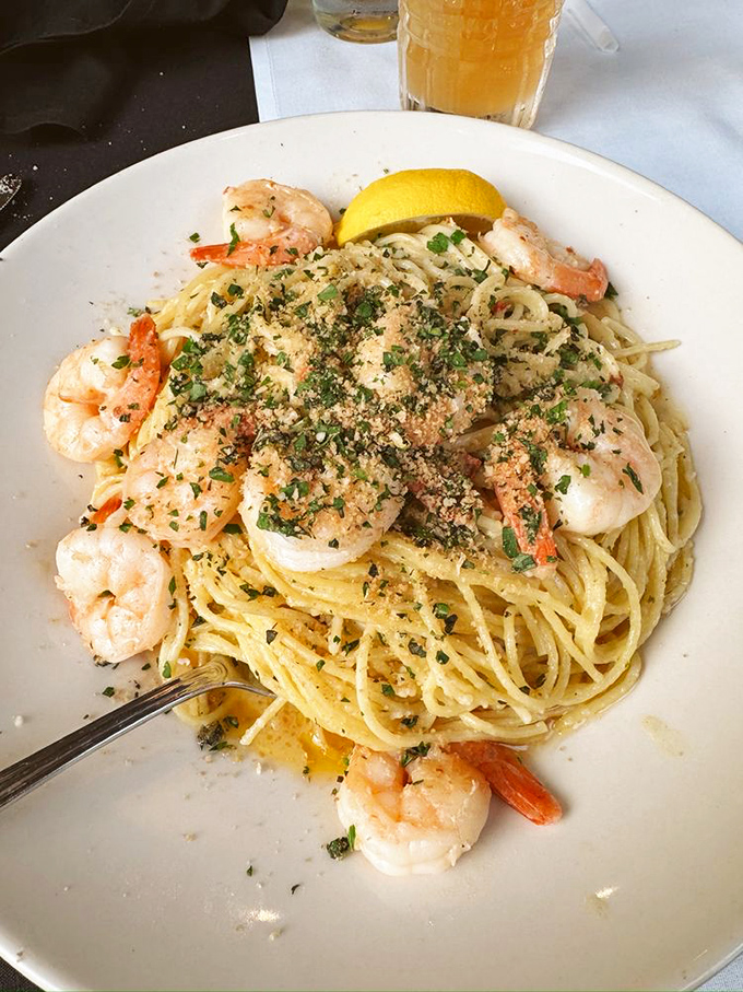 Shrimp scampi that's dressed for success – plump crustaceans perched atop pasta strands glistening with garlic butter and sprinkled with herbs.