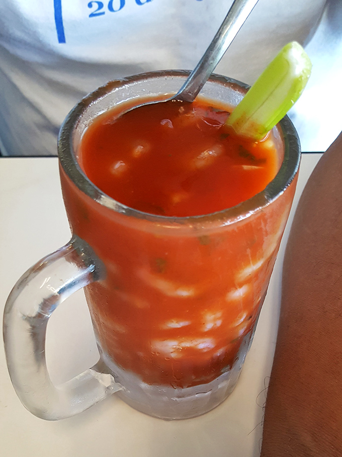 A Bloody Mary garnished with celery that's not just a drink—it's practically a pre-appetizer appetizer for serious food enthusiasts.