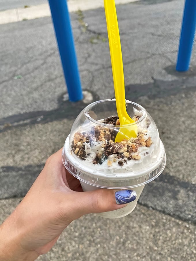 Layers of vanilla soft serve, crunchy mix-ins, and whipped cream—a textural symphony in a cup that demands a slow-motion spoon.