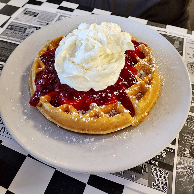 A Belgian waffle crowned with strawberries and whipped cream – dessert masquerading as breakfast, and nobody's complaining.