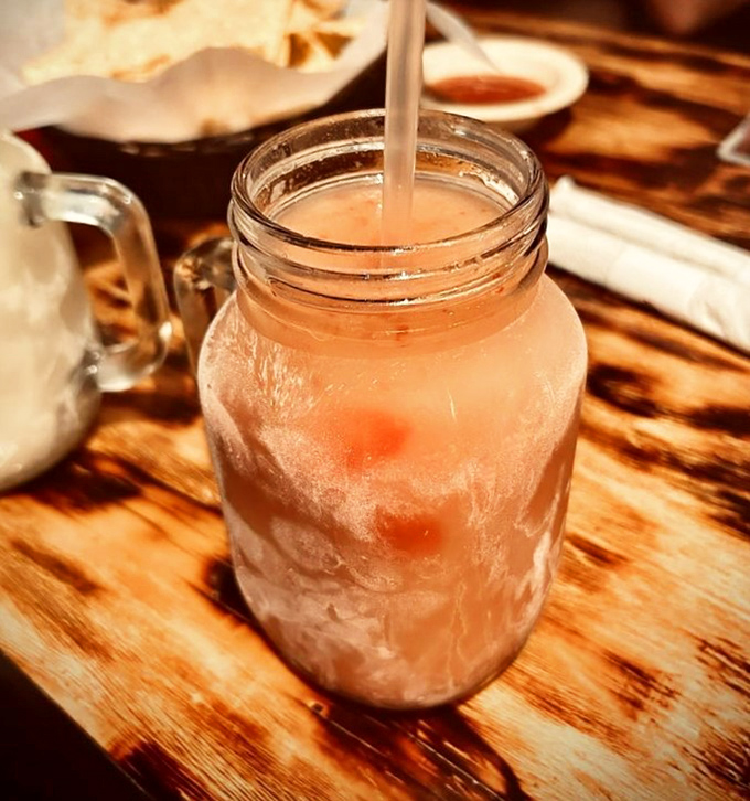 That mason jar isn't just holding a strawberry drink—it's containing summer itself, one refreshing sip at a time.