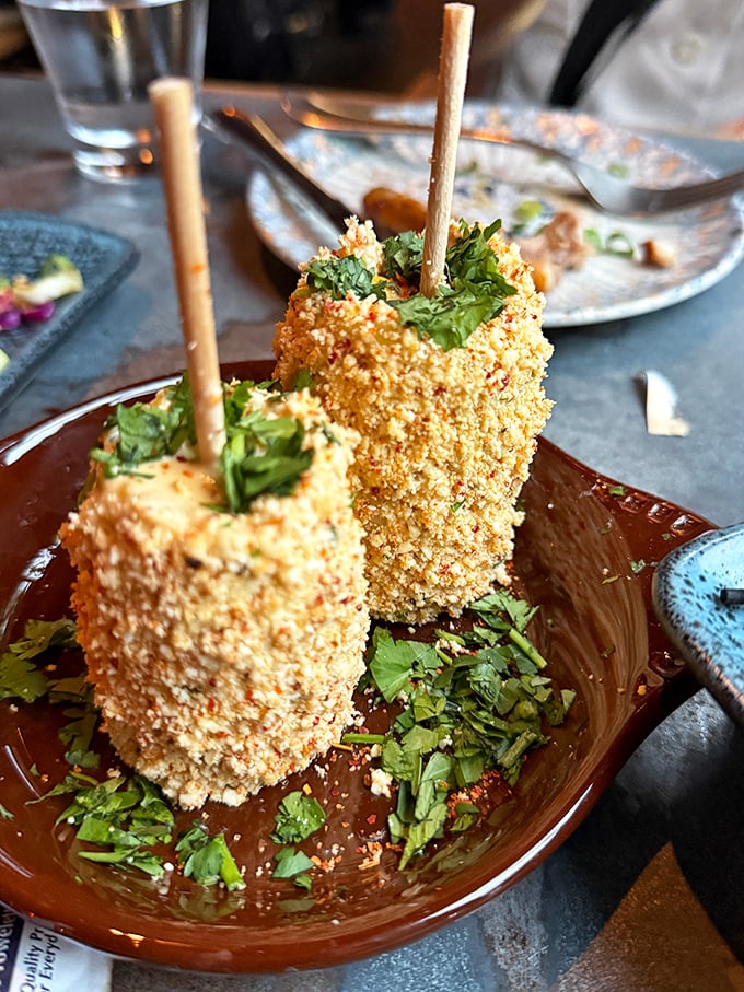 Street corn elevated to art form – these golden-crusted corn fritters on sticks are what carnival food dreams of becoming when it grows up.