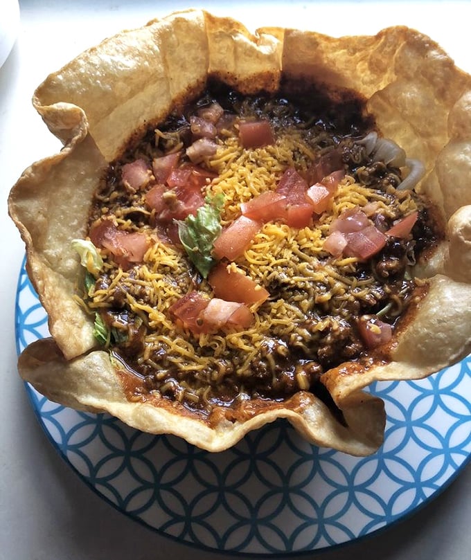 Taco salad in an edible bowl—where the line between "I should stop eating" and "I'm definitely eating this entire shell" disappears completely.