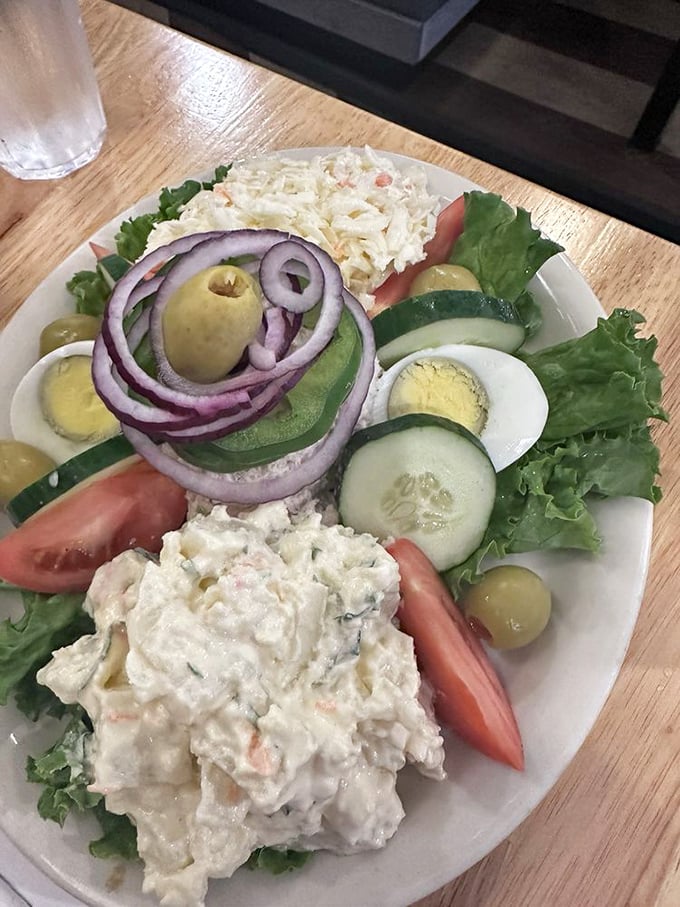 A tuna salad platter that respects vegetables enough to give them equal billing. That ring of red onion is practically architectural.