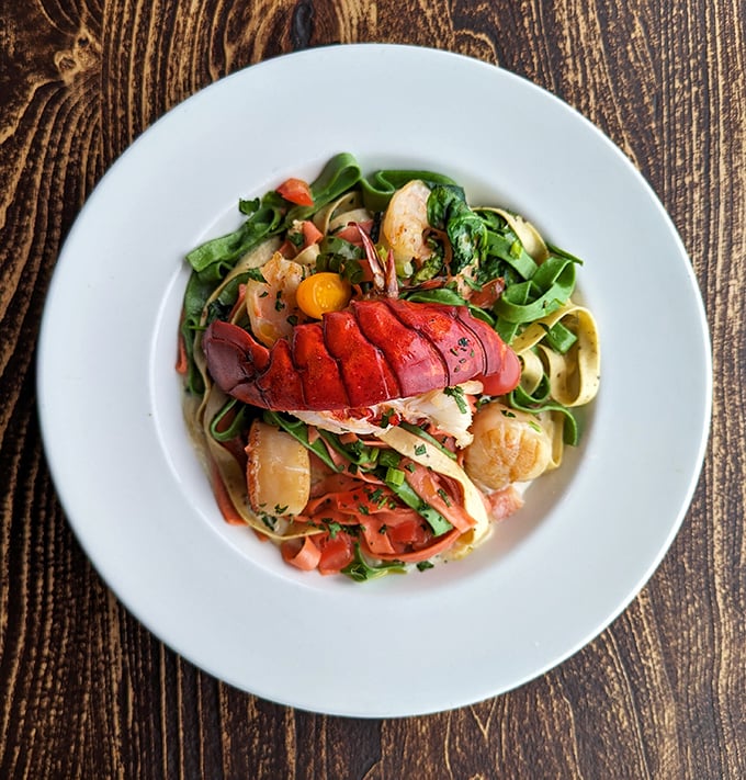 Lobster pasta that makes you wonder why we ever bothered putting seafood on anything else. Those colors aren't a dish—they're a celebration.