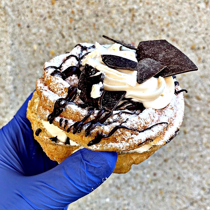 A cream puff held by gloved hands - pastry so good it requires protection, either from contamination or from being snatched by passing pastry enthusiasts.