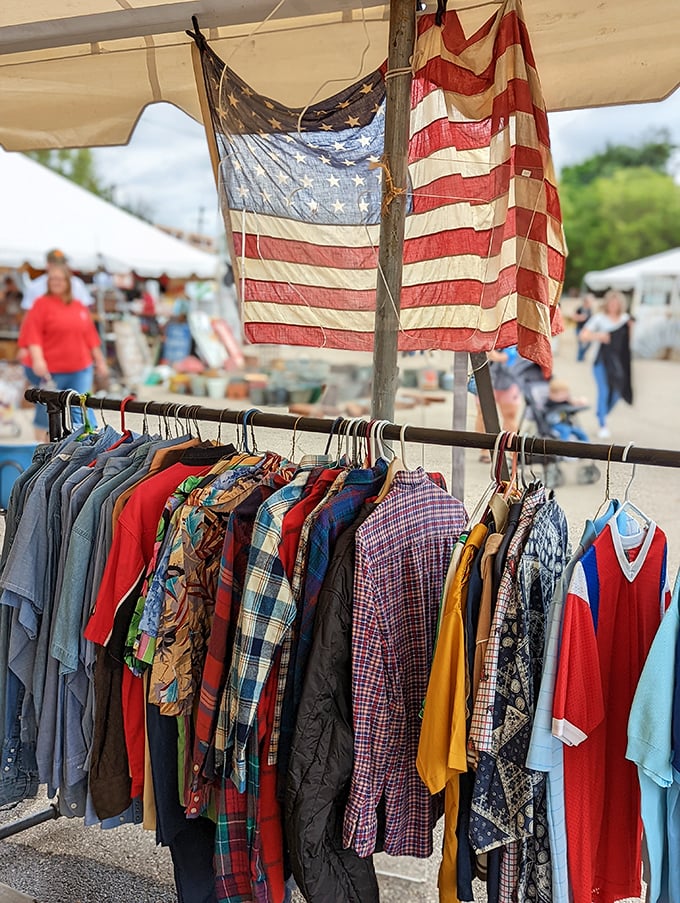 Vintage clothing under vintage flags—patriotic shopping at its finest. That plaid shirt has stories to tell if fabric could talk.