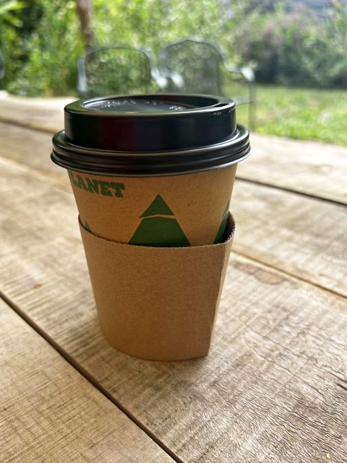 Coffee on the porch: a simple pleasure elevated to art form. The eco-friendly sleeve isn't just holding your cup—it's hugging the planet too.