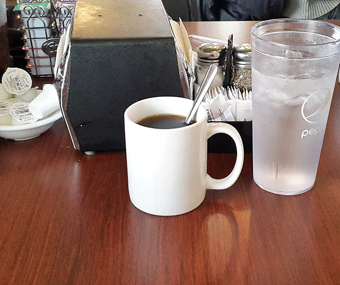 The unsung hero of every diner experience—a sturdy mug of coffee that doesn't need a fancy Italian name to get the job done. 