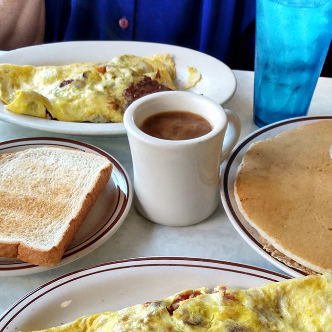 The breakfast spread that dreams are made of—golden omelets, buttery toast, steaming coffee, and pancakes that make you question whether you should even attempt to finish them.