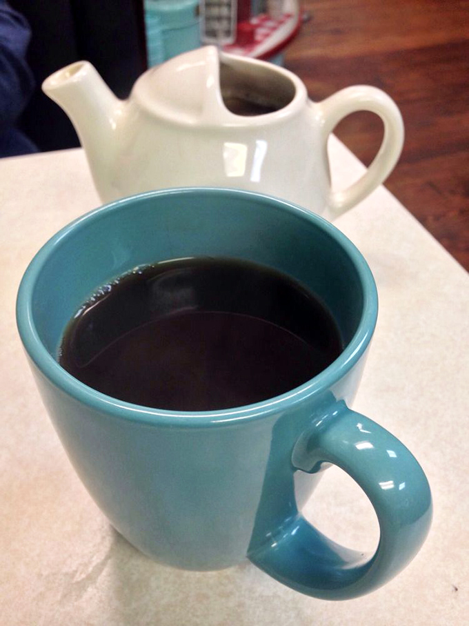 That turquoise mug isn't just serving coffee—it's delivering liquid motivation in a color that matches the diner's soul. The individual pot is pure diner luxury.