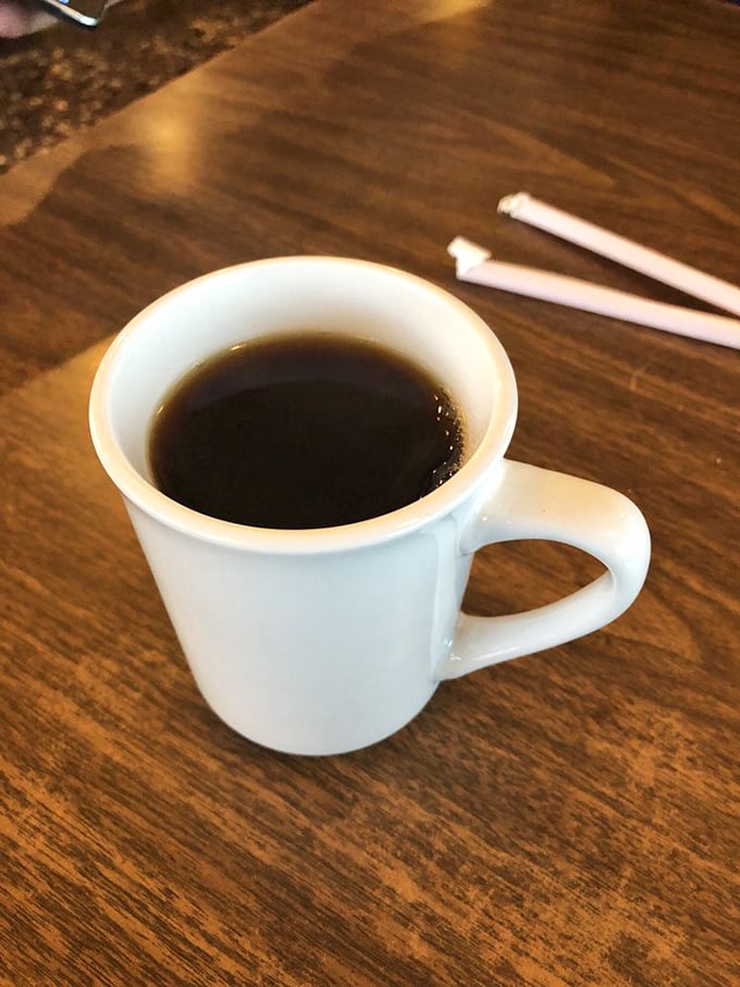 That humble white mug holds liquid persistence—the kind of honest, robust coffee that doesn't need fancy names or elaborate preparation to get you through your day.