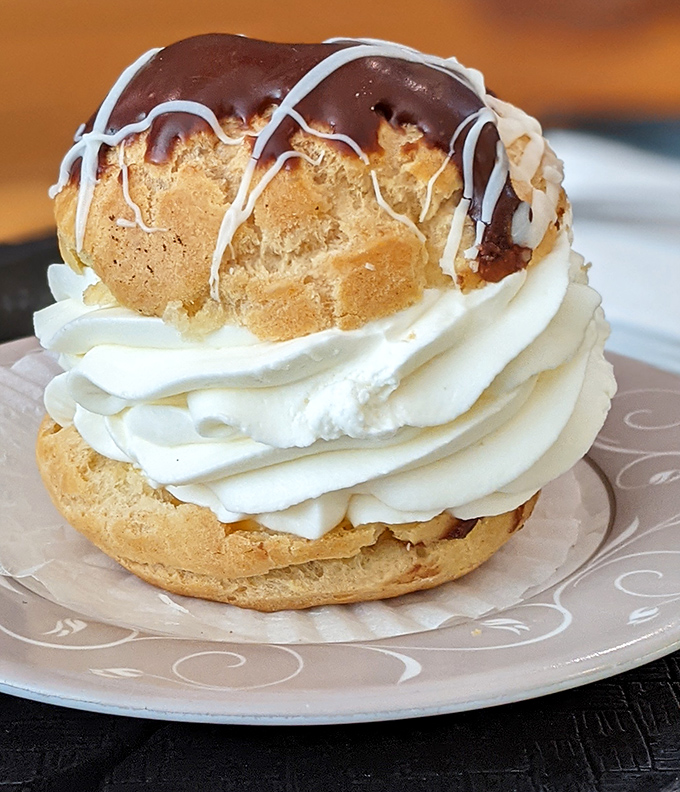 This cream puff doesn't just have layers, it has a storyline—crisp pastry, billowing cream, and a chocolate-drizzled finale that deserves a standing ovation.