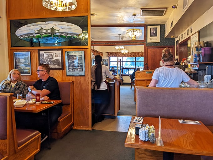 Classic diner booths where breakfast memories are made. That stained glass window isn't just decoration—it's a portal to pancake paradise.