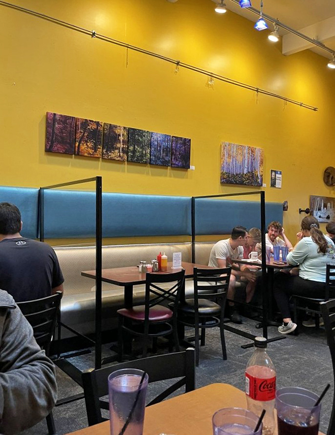 Local artwork adorns sunny yellow walls while diners enjoy that perfect breakfast buzz—the kind where conversation flows as freely as the coffee.