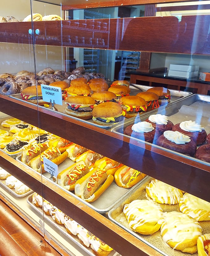 The display case – where hamburger donuts and cream-filled long johns compete for your attention in the most delicious standoff in town.