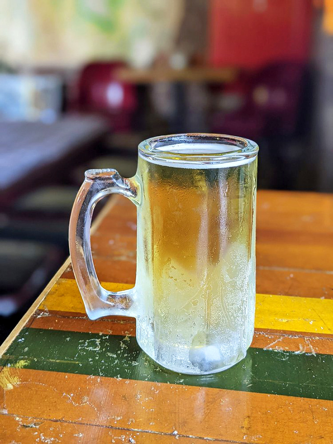 A frosty mug of beer sits expectantly on a colorful table – the perfect silent partner to fried chicken's boisterous personality.