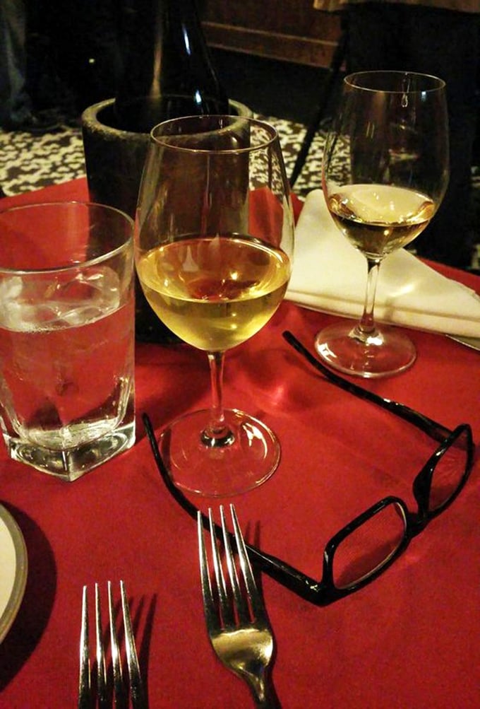 Wine glasses catching the light on a red tablecloth—the universal signal that good decisions are being made and memorable conversations are about to begin.