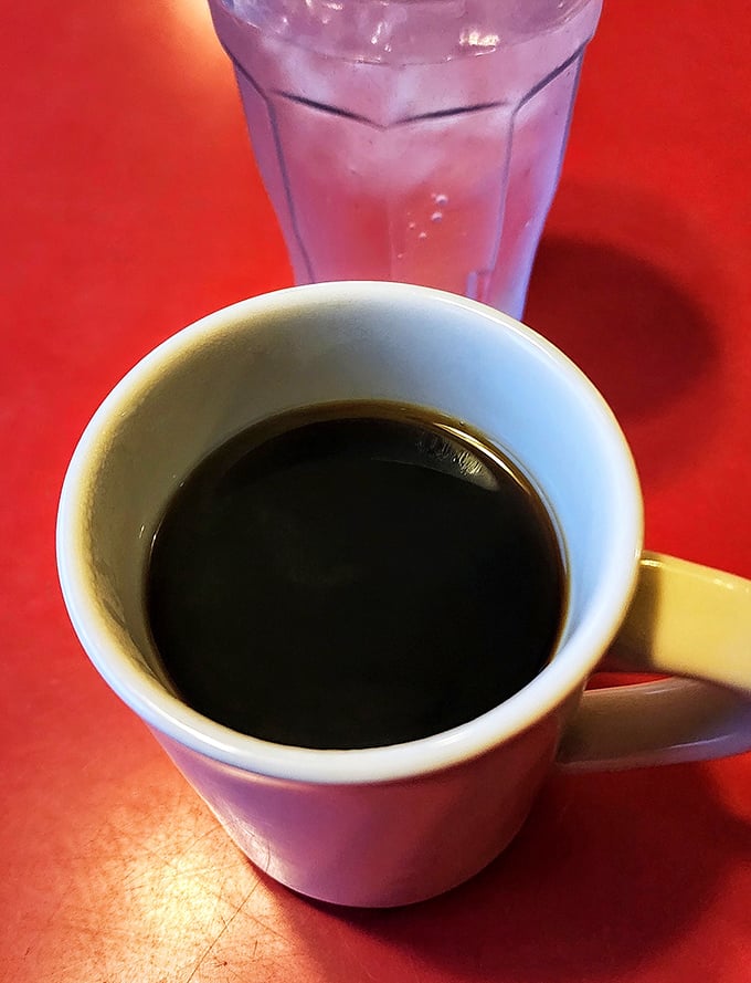 The diner coffee ritual – strong, honest brew in a sturdy mug with ice water on standby. No foam art needed when the coffee's this good.
